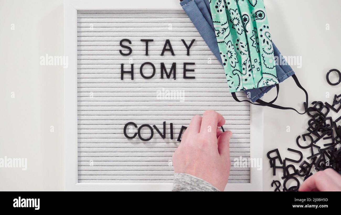 Flat lay. STAY HOME and COVID-19 sign on message board with a homemade ...