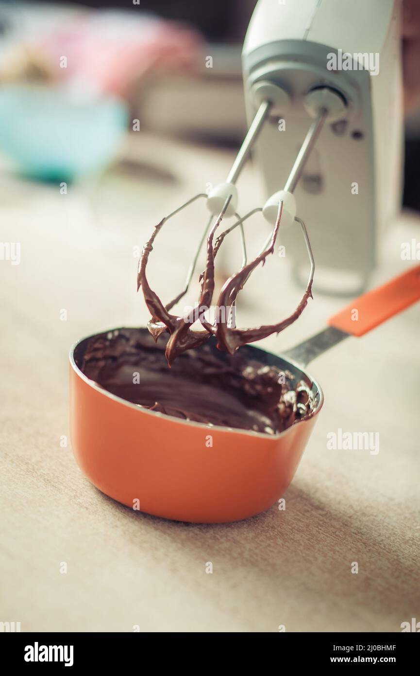 Woman hands mixing melted chocolate in the kitchen. Close up Stock ...