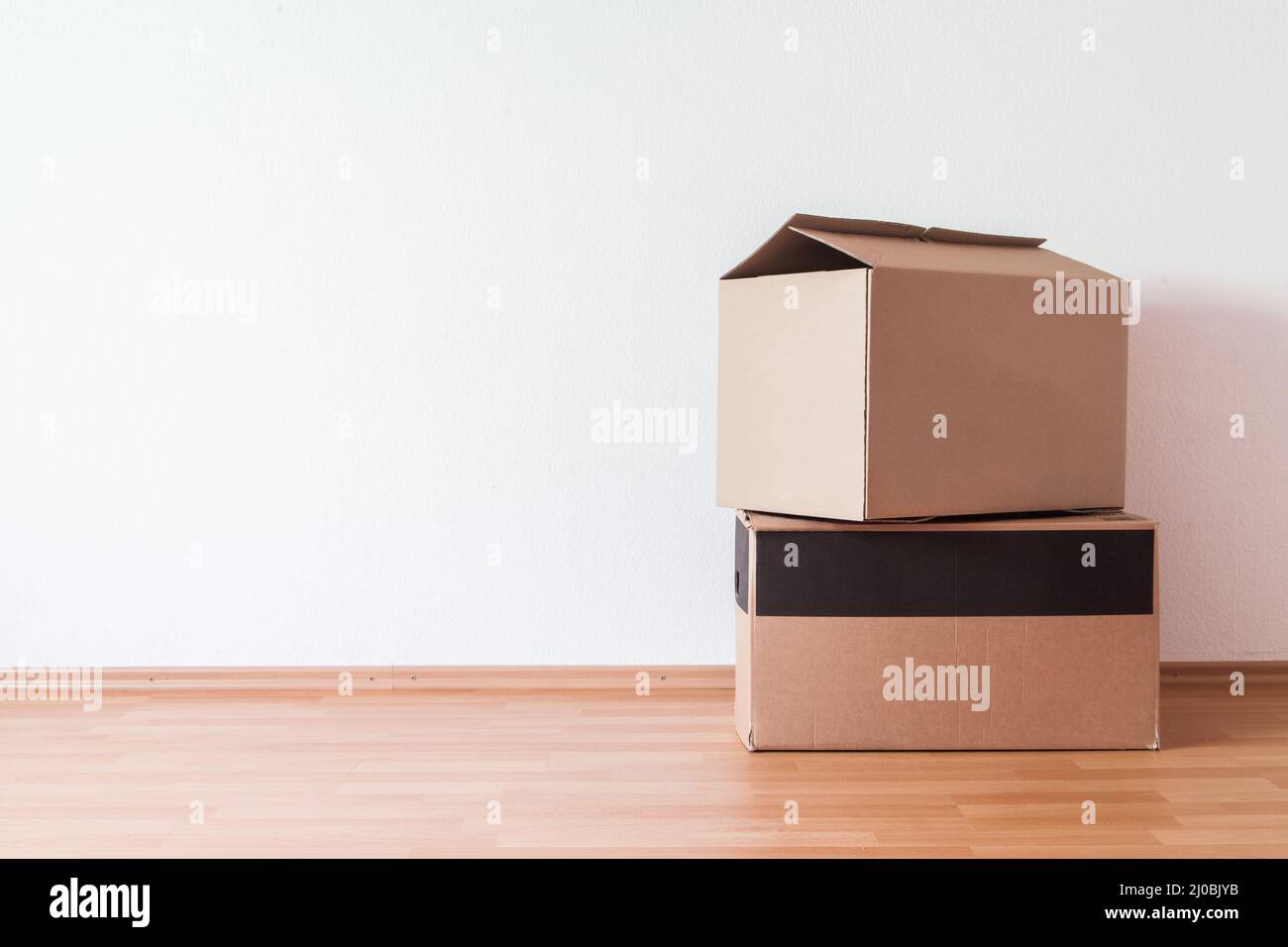Boxes on the floor in the corner of a room Stock Photo - Alamy