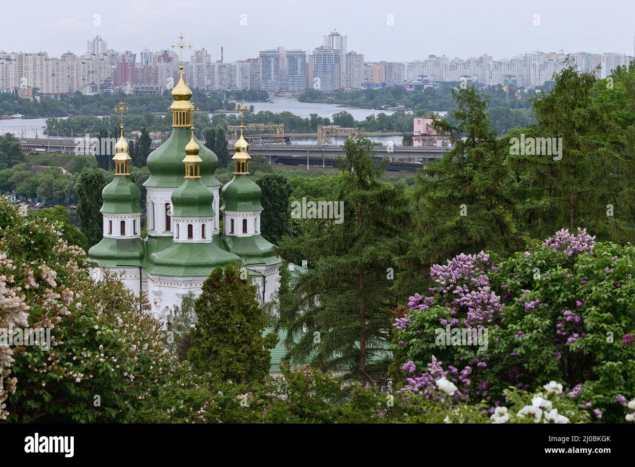 Urban landscape with a blooming garden and the Vydubychi Monastery in ...