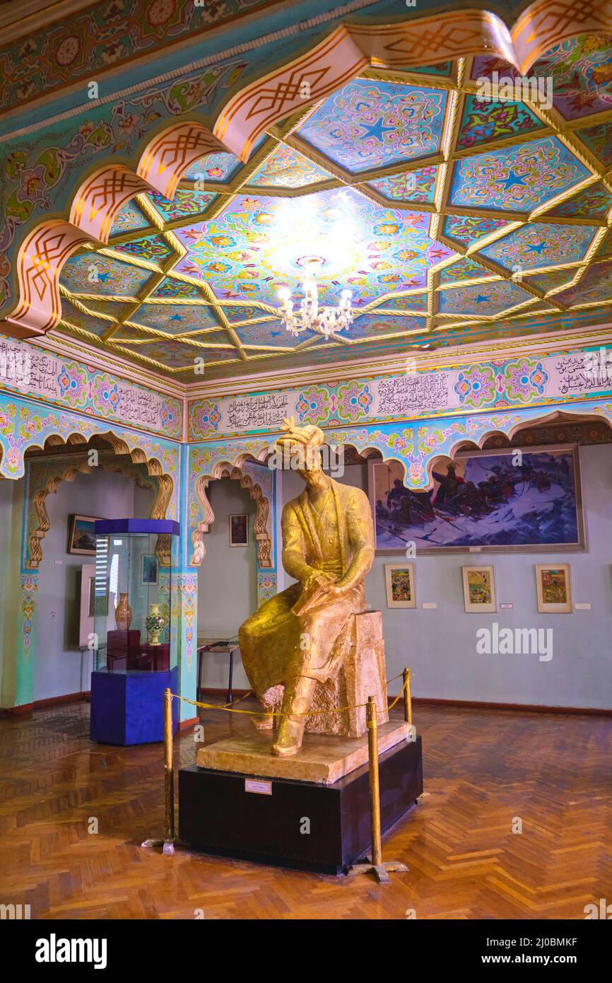 A large, gold statue, sculpture of a sitting Bobur. At the Alisher ...