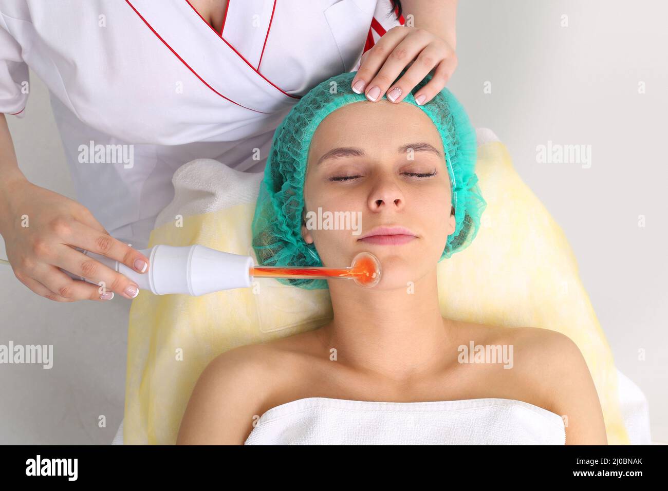 Receiving electric darsonval facial massage procedure Stock Photo - Alamy