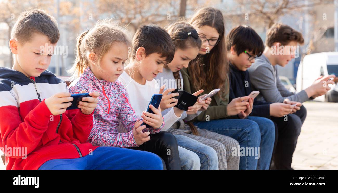 Children addicted in their phones outdoors Stock Photo - Alamy