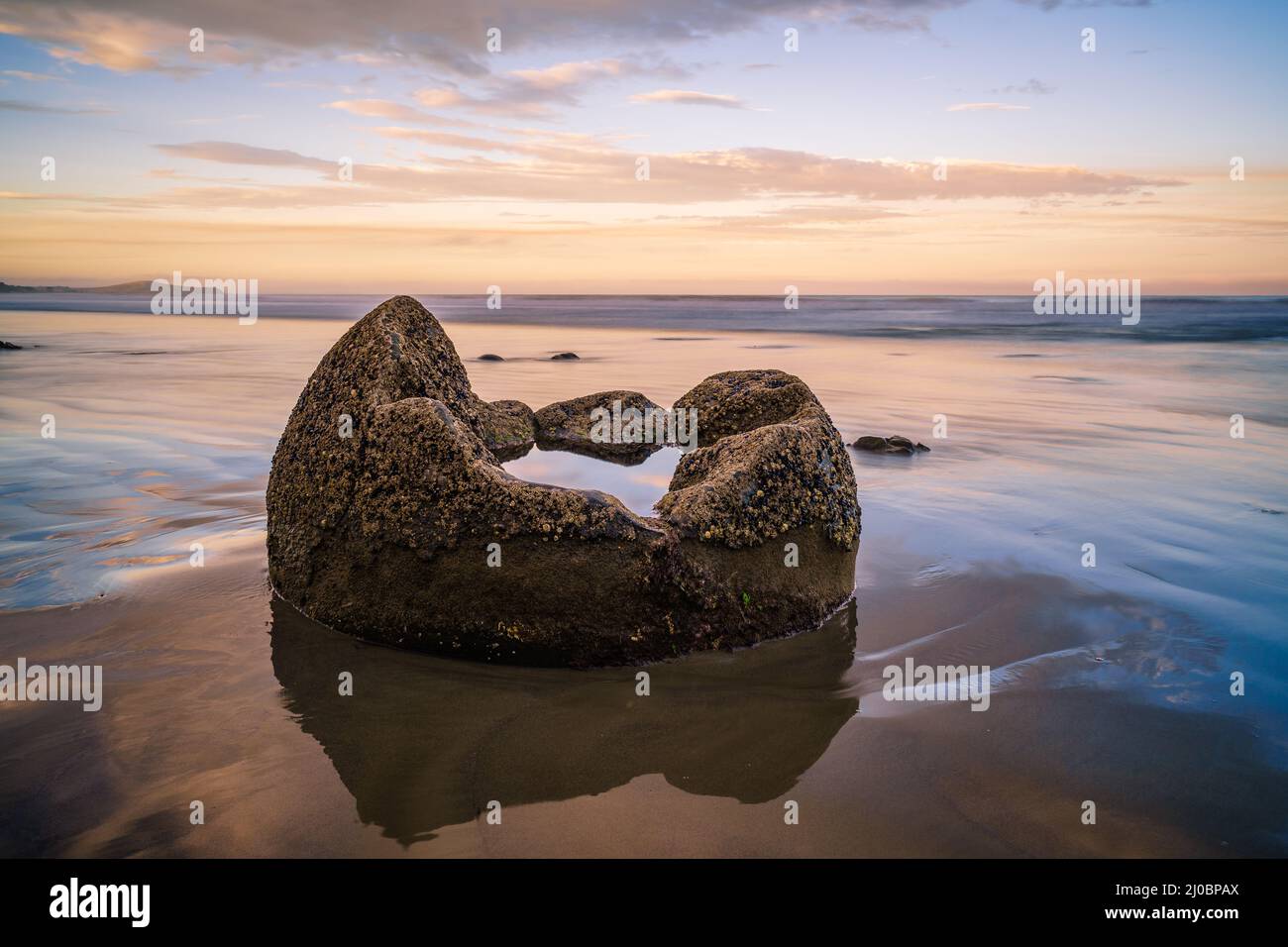 Photo of big round broken rock in water in New Zeland Stock Photo - Alamy