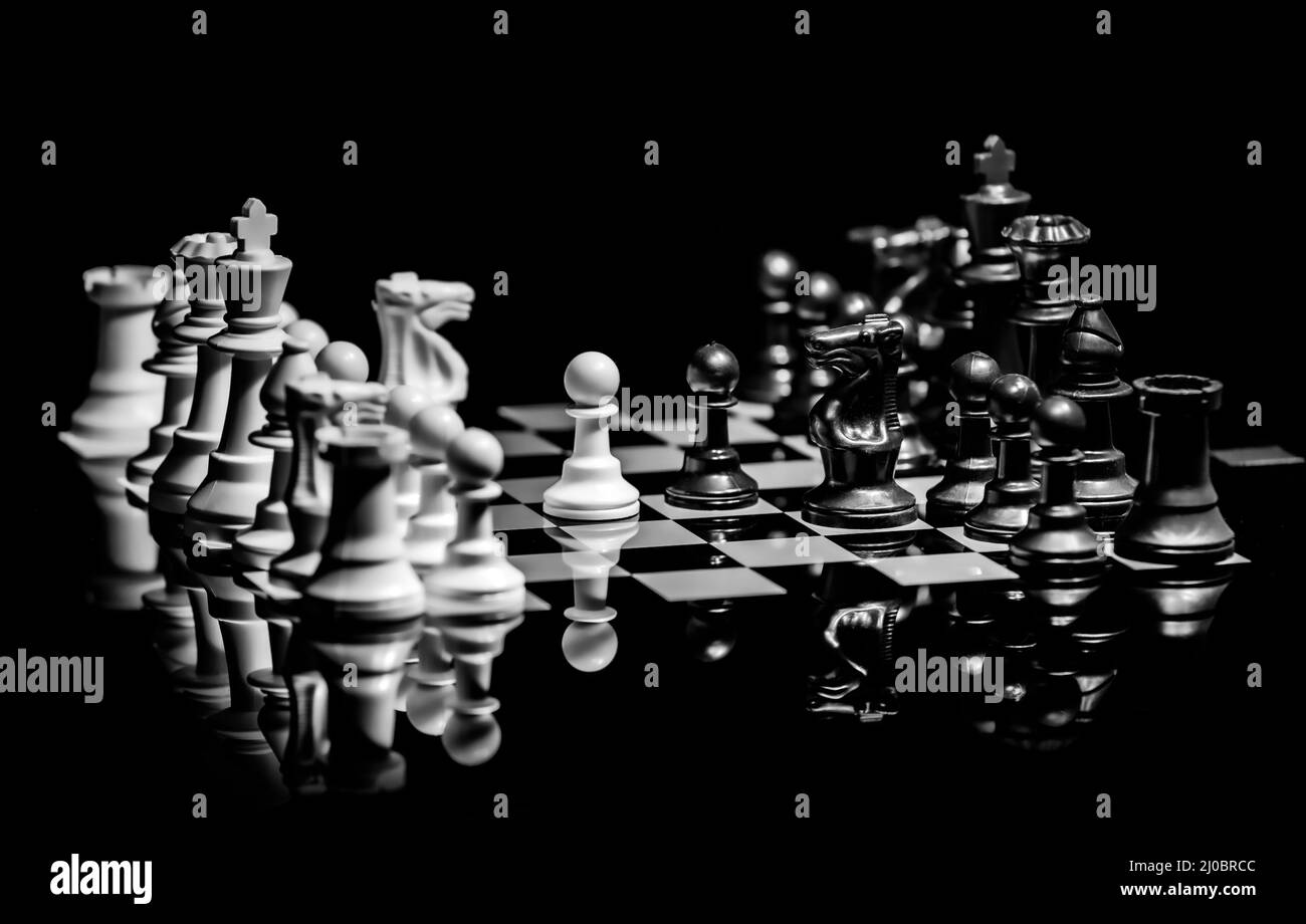 Close up of Chess pieces on a reflective mirror board surface with a ...