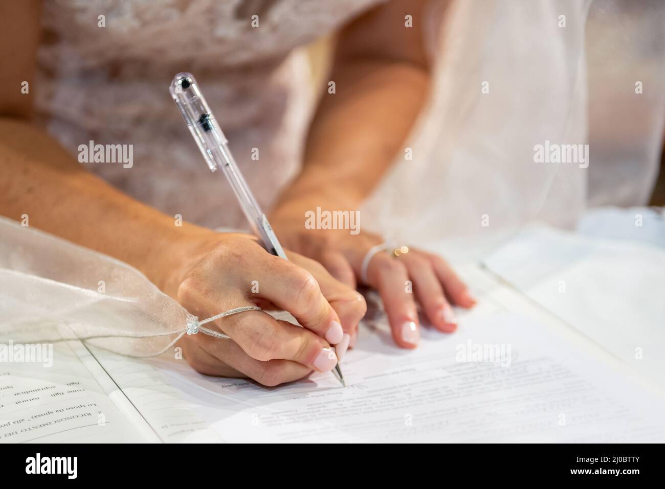 March 2022, Young bride's hand signs the marriage register Stock Photo ...