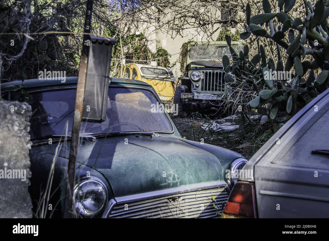 Retro small car in the parking of destroyed old cars Stock Photo - Alamy