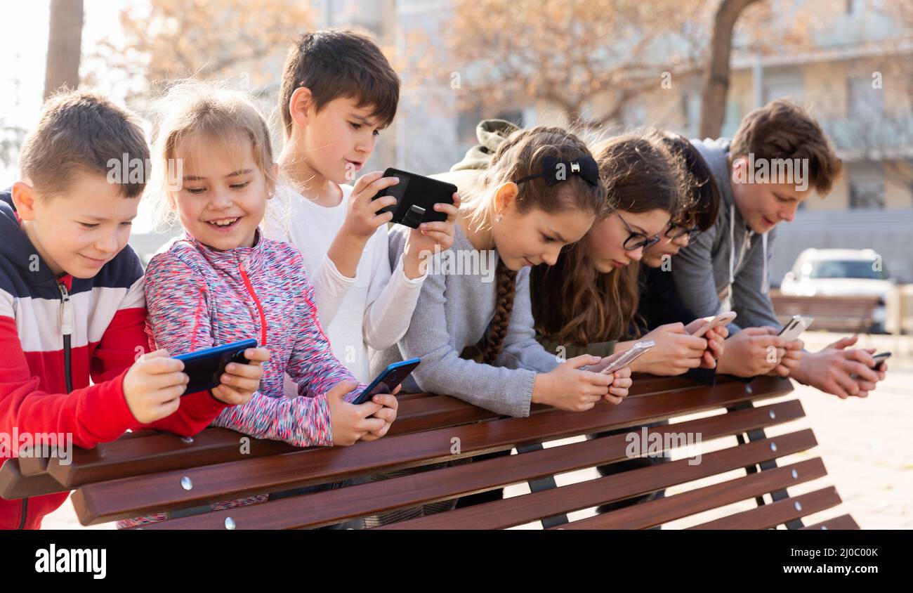 Children are playing on smartphone in the playground Stock Photo - Alamy