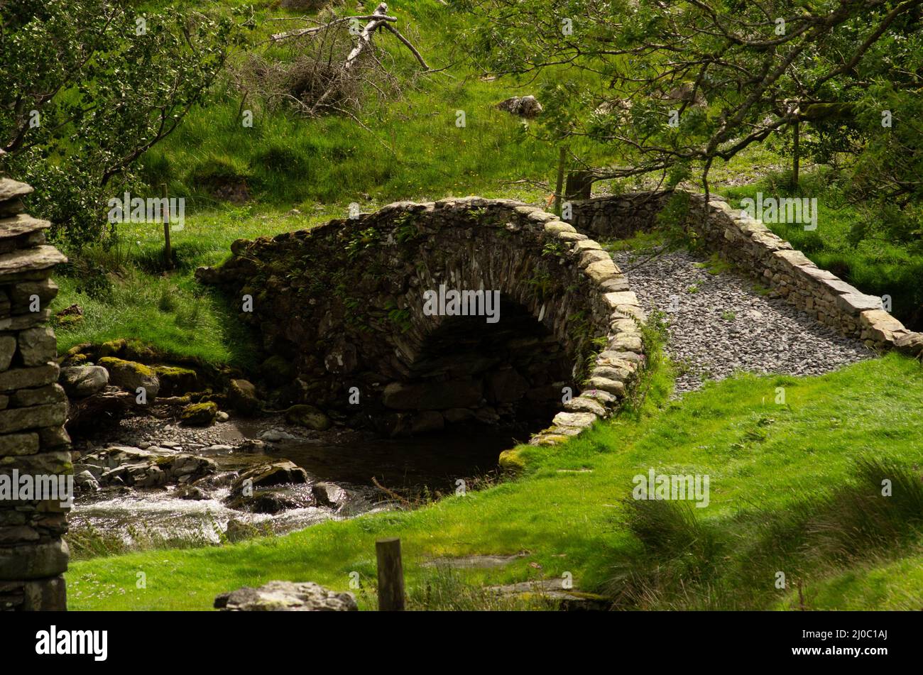 Curved old fashioned brick and cobble footbridge over a river Stock ...