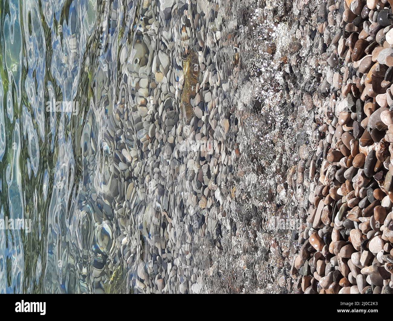 Clean sea water and stones Stock Photo - Alamy