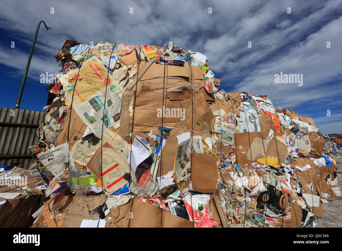 Altpapier und Karton in Bündeln auf einer Recyclinganlage / Waste paper ...