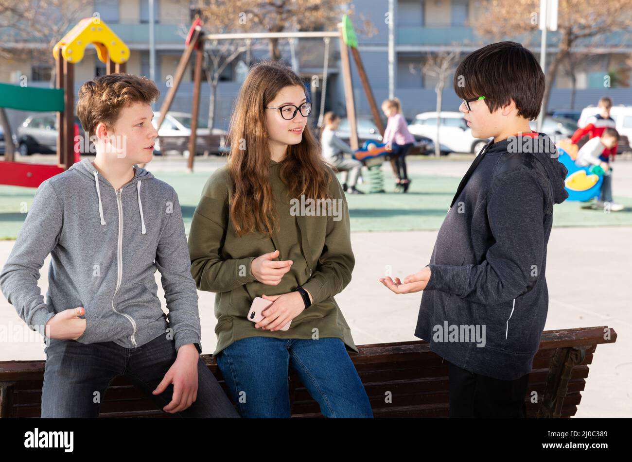 Children talking on bench on playground Stock Photo - Alamy
