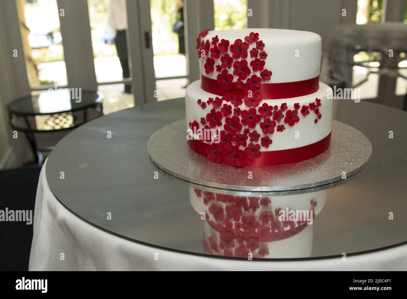 Two-floor floral cake on a round table in a room with white doors Stock ...