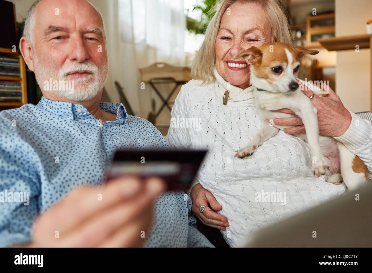 Couple of seniors using credit cards doing online shopping on laptop ...