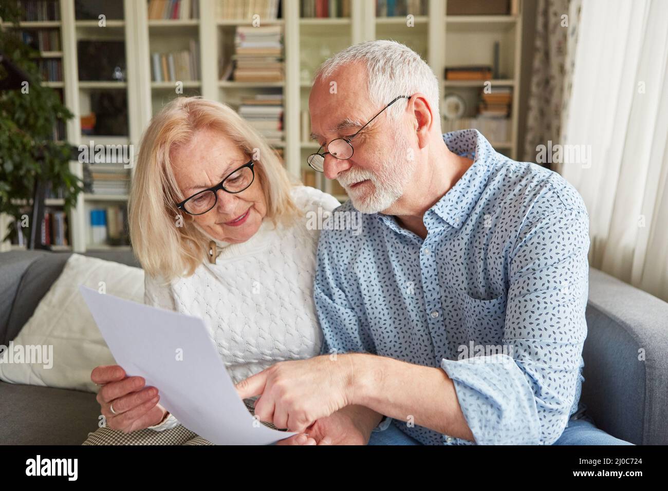 Senior couple reading a retirement plan or power of attorney or living ...