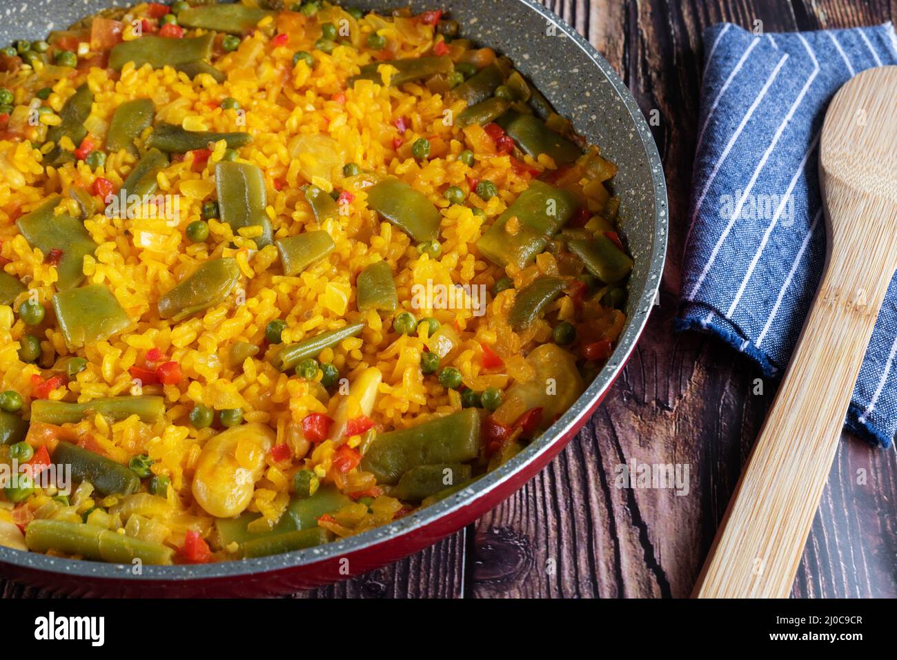 Rice paella with vegetables on a rustic background Stock Photo - Alamy