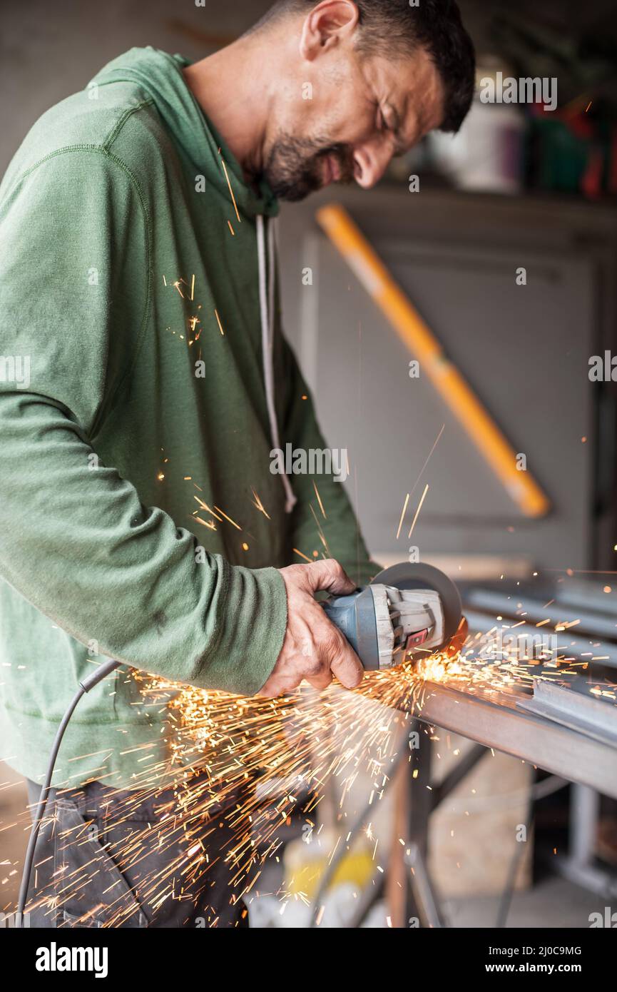 Electric wheel grinding on steel structure in factory. Sparks from the ...