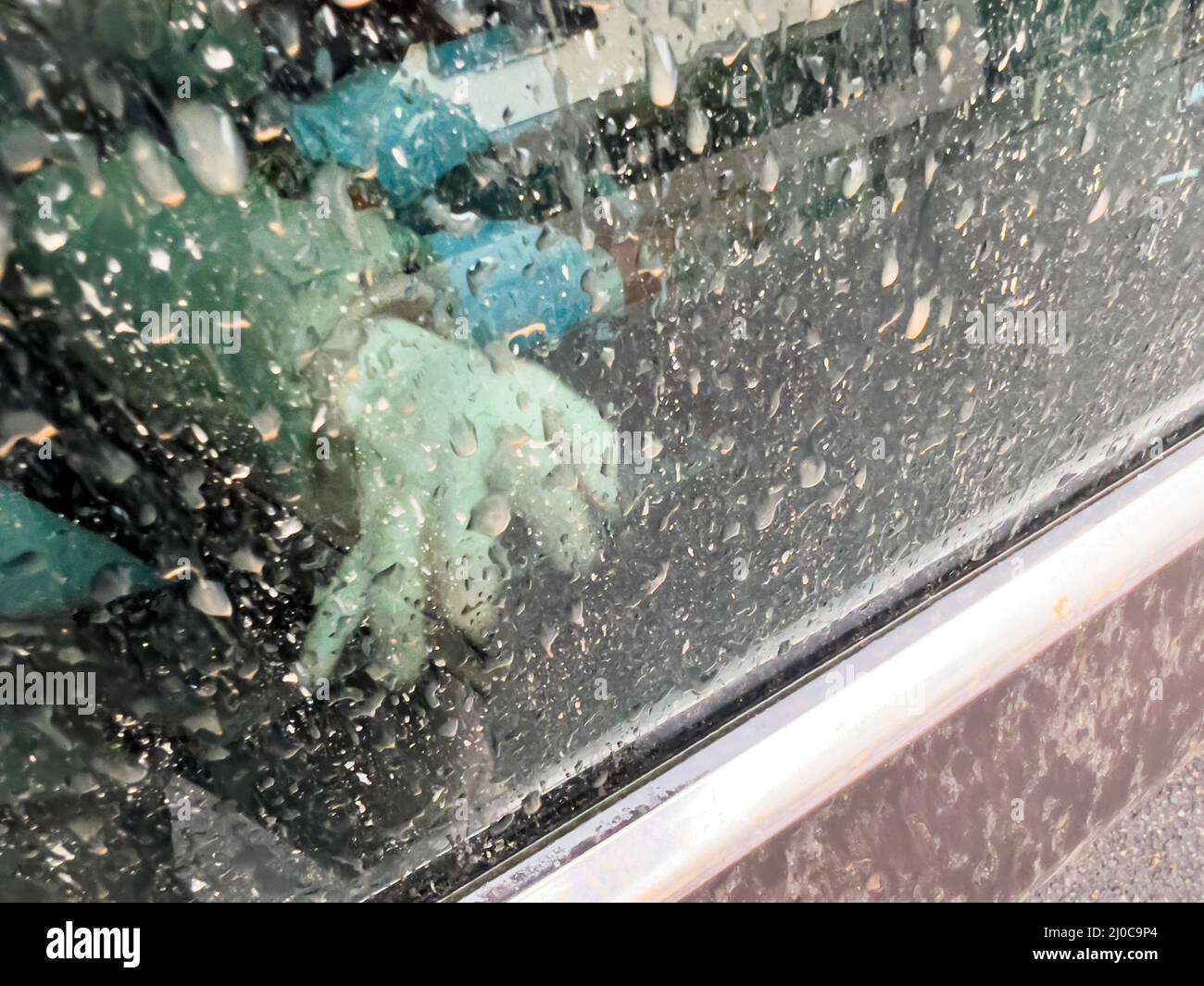 Abstract image of baby hand seen inside dirty car from sahara dust ...