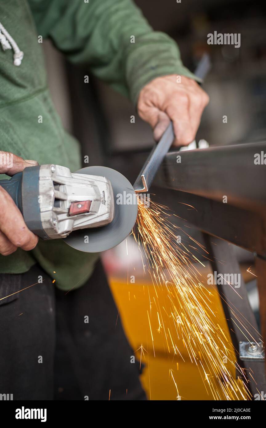 Electric wheel grinding on steel structure in factory. Sparks from the ...