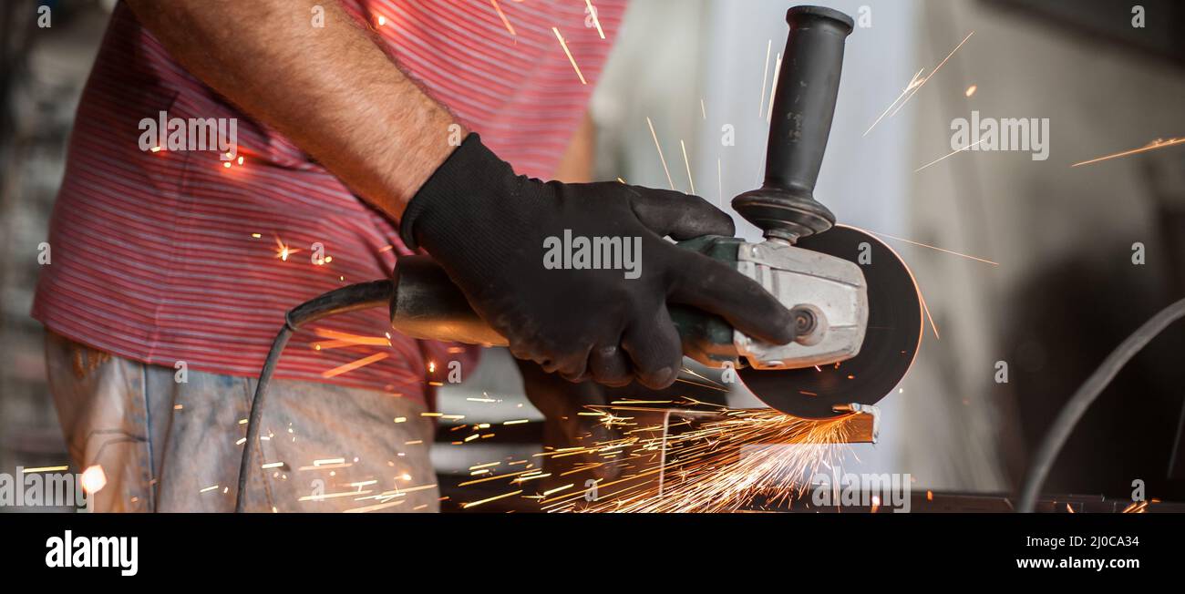 Electric wheel grinding on steel structure in factory. Sparks from the ...