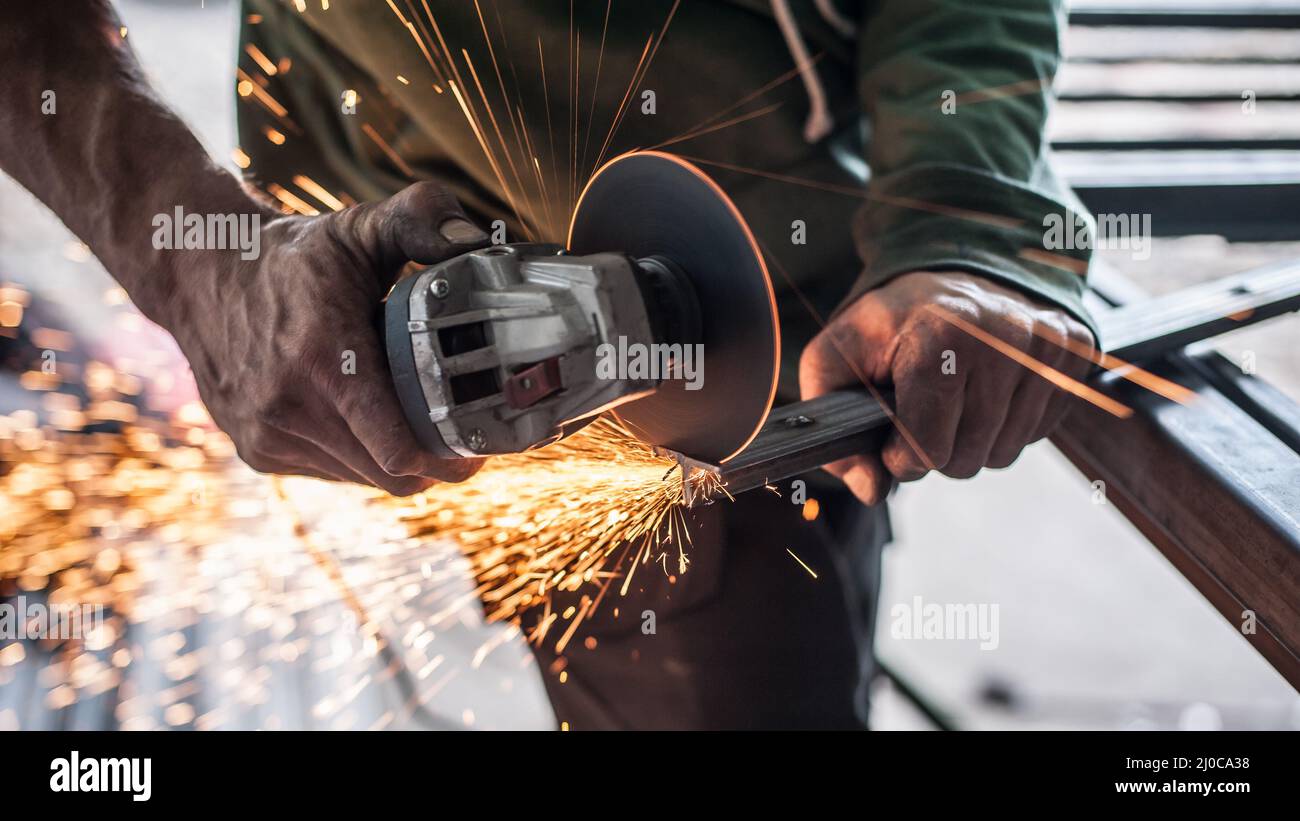 Electric wheel grinding on steel structure in factory. Sparks from the ...