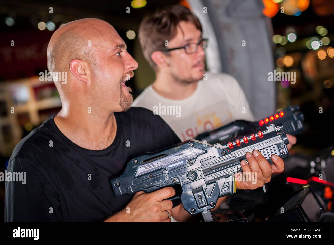 Friends playing with a toy shotgun on target in room Stock Photo - Alamy
