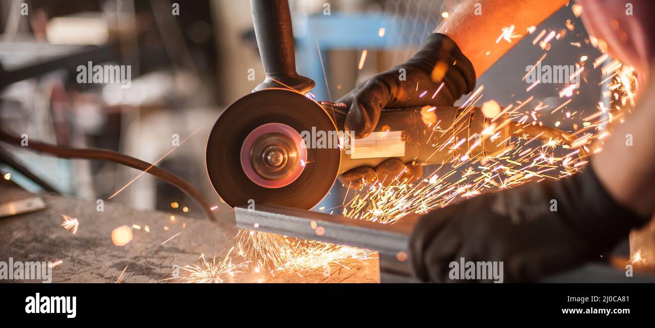 Electric wheel grinding on steel structure in factory. Sparks from the ...