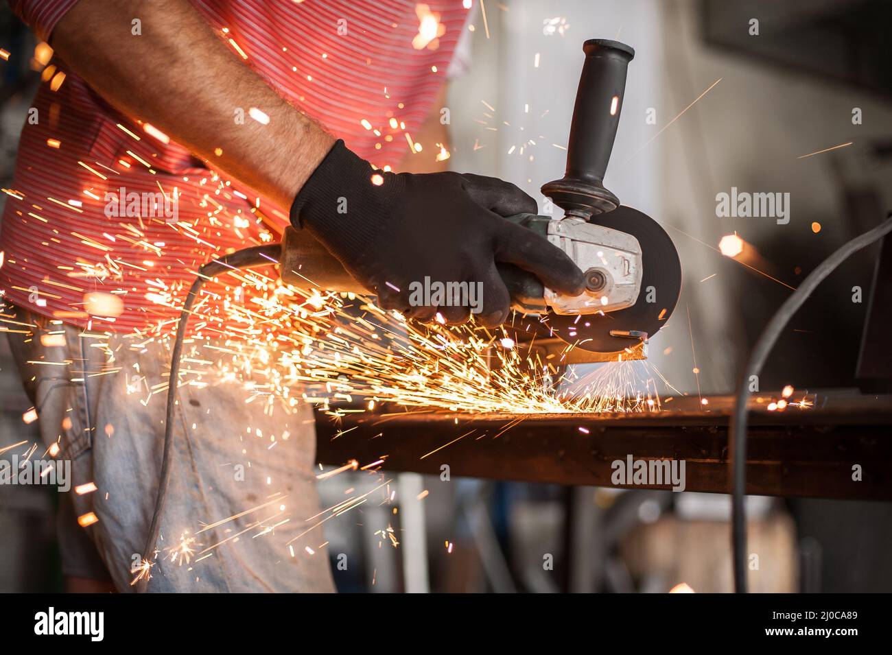 Electric wheel grinding on steel structure in factory. Sparks from the ...