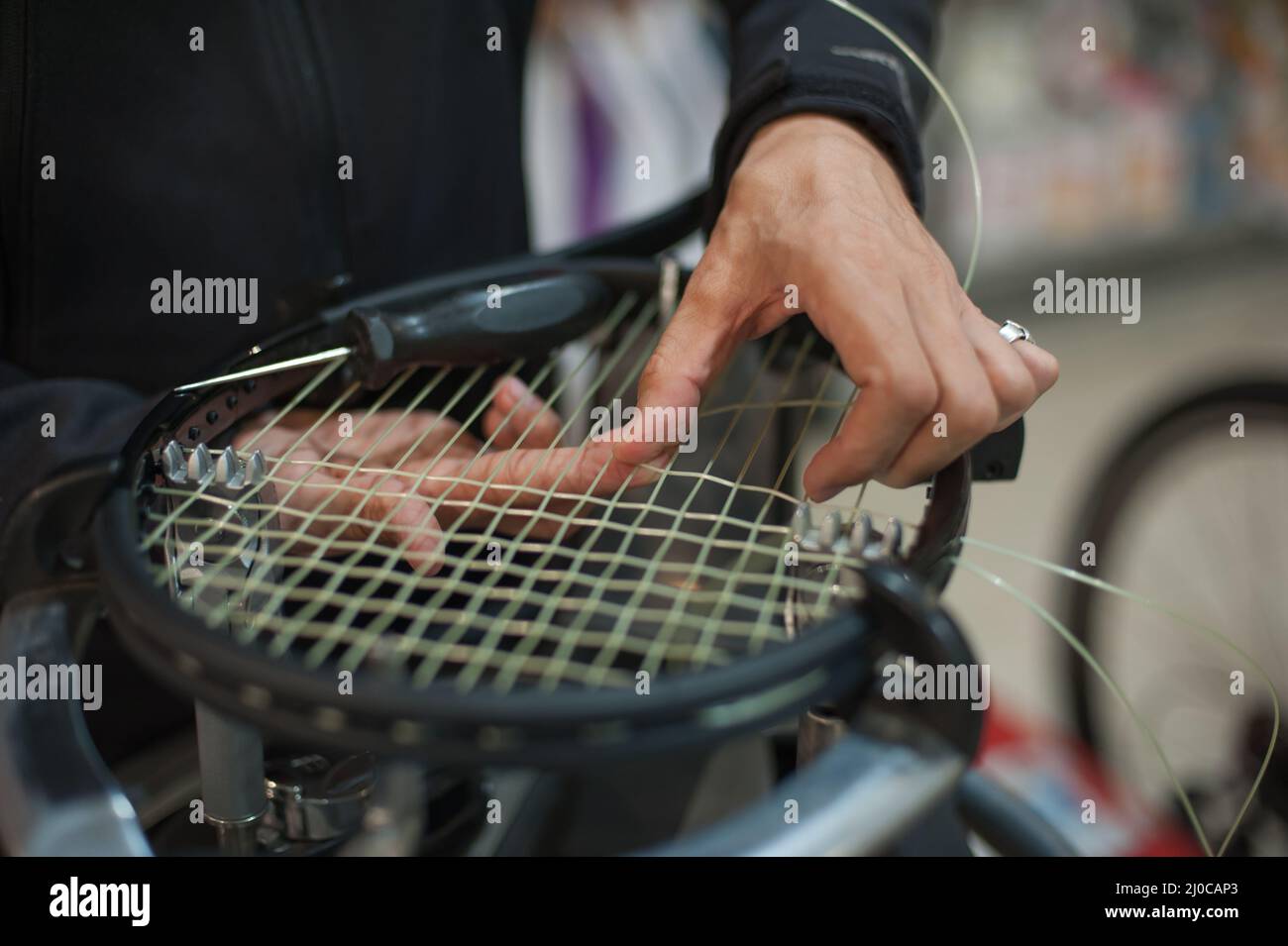 Stringing Machine. Close up of tennis stringer hands doing racket ...