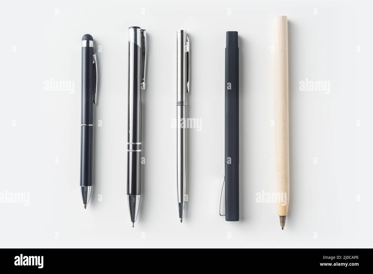 Top view of collection of pens on white background desk for mockup ...
