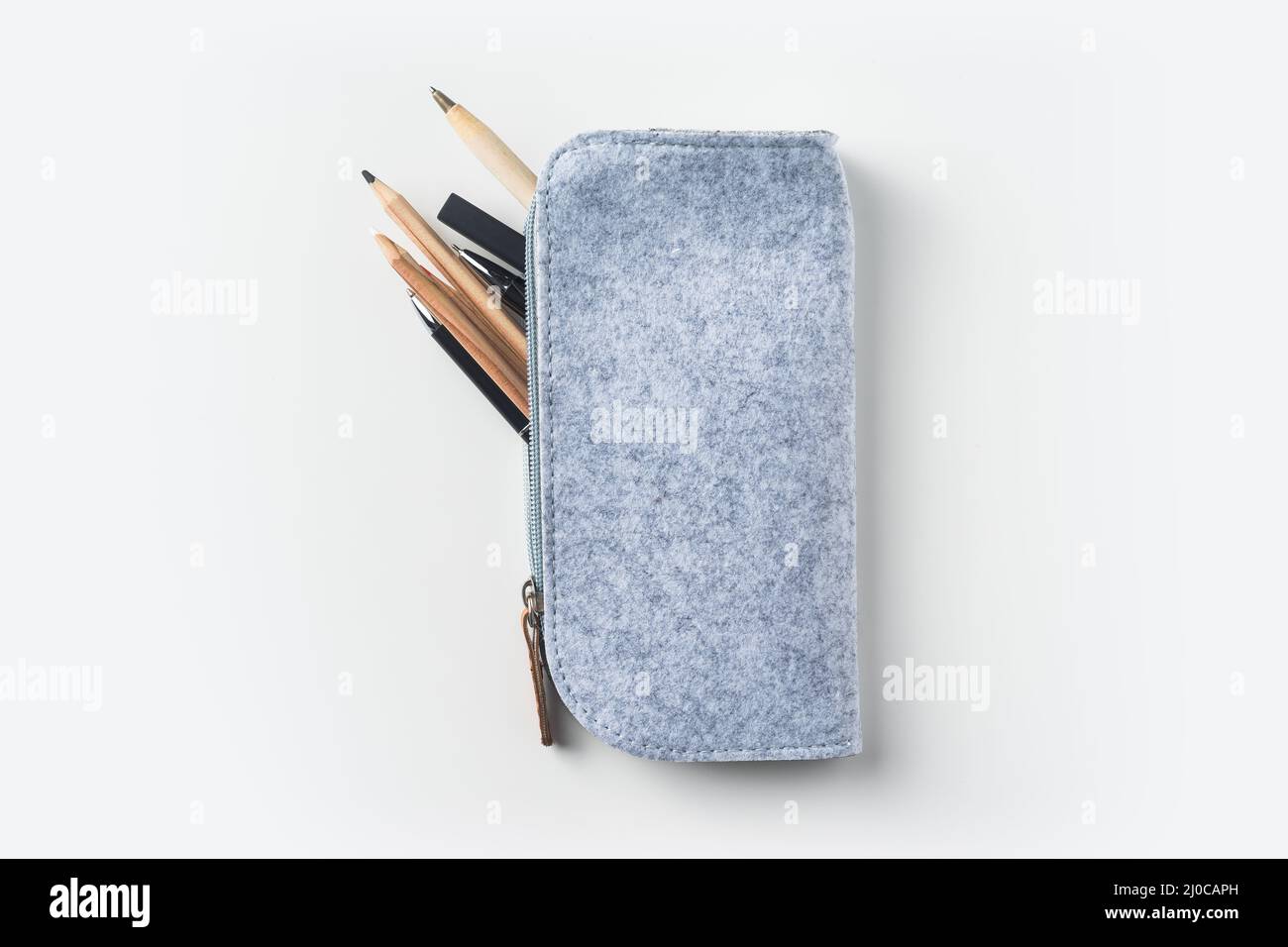 Top view of grey fabric pencil case with lot of pens on white ...