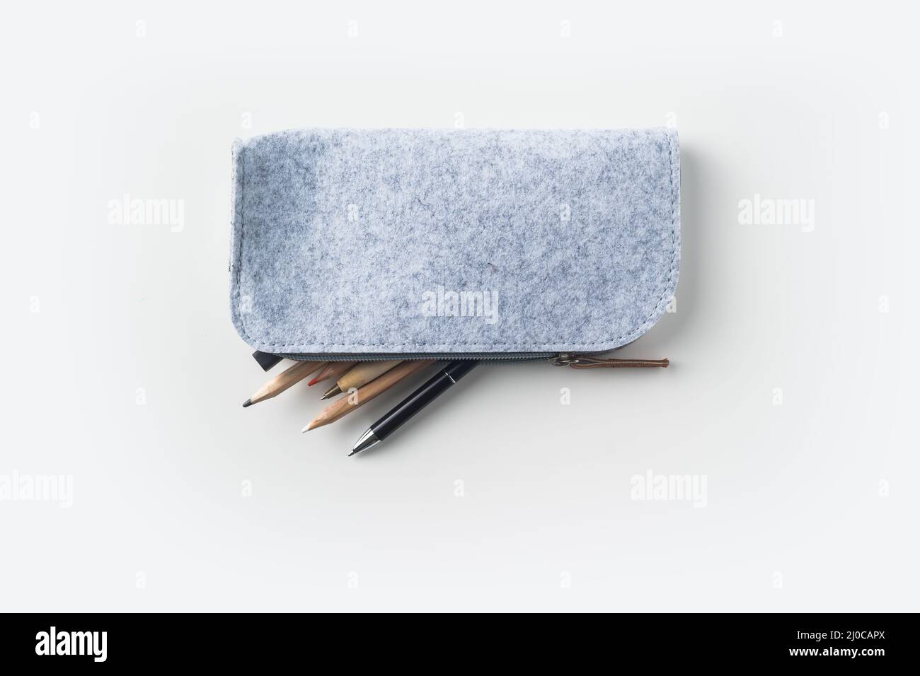 Top view of grey fabric pencil case with lot of pens on white ...