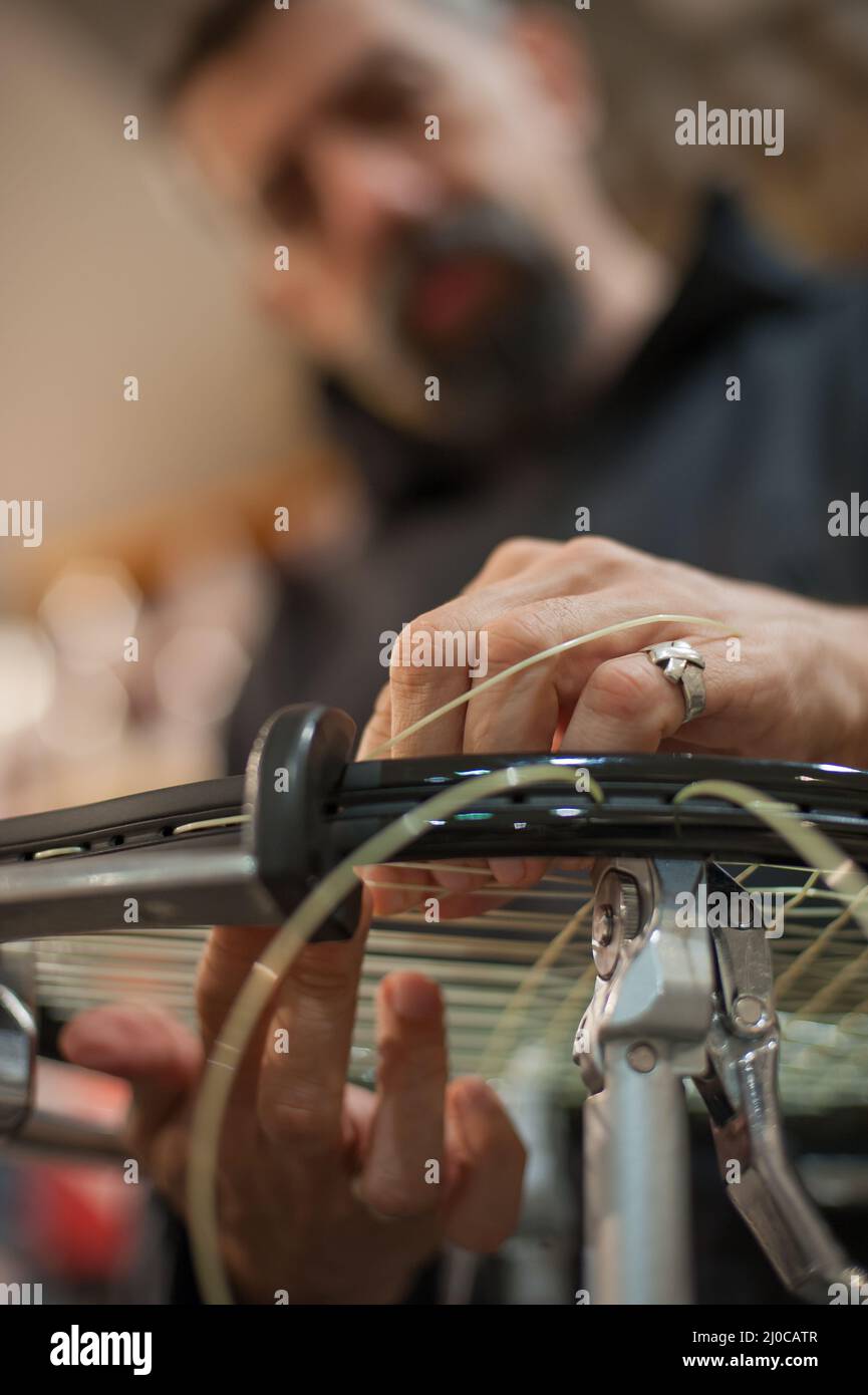 Stringing Machine. Close up of tennis stringer hands doing racket ...