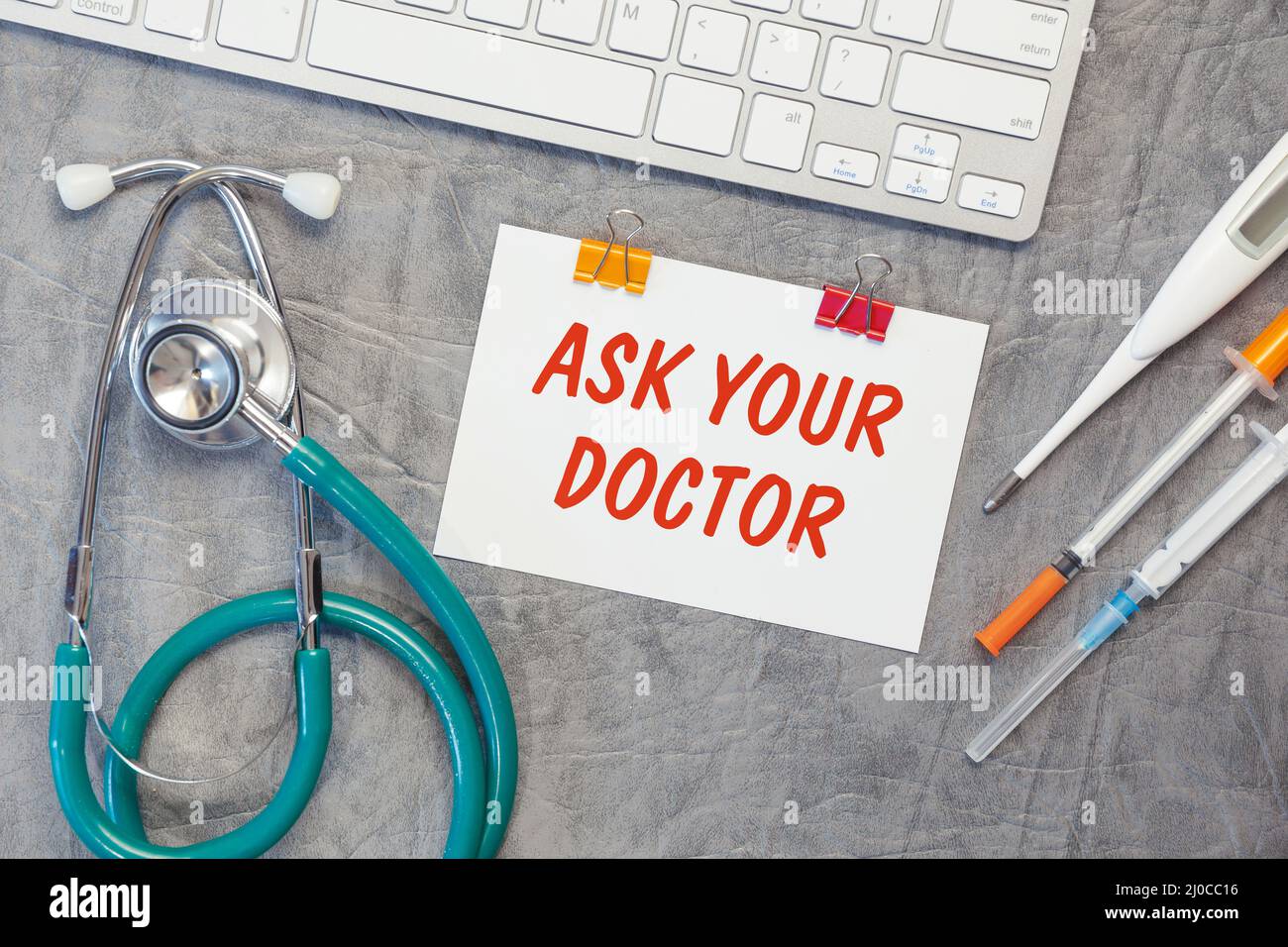 Paper with ASK YOUR DOCTOR on the office desk, stethoscope and keyboard ...