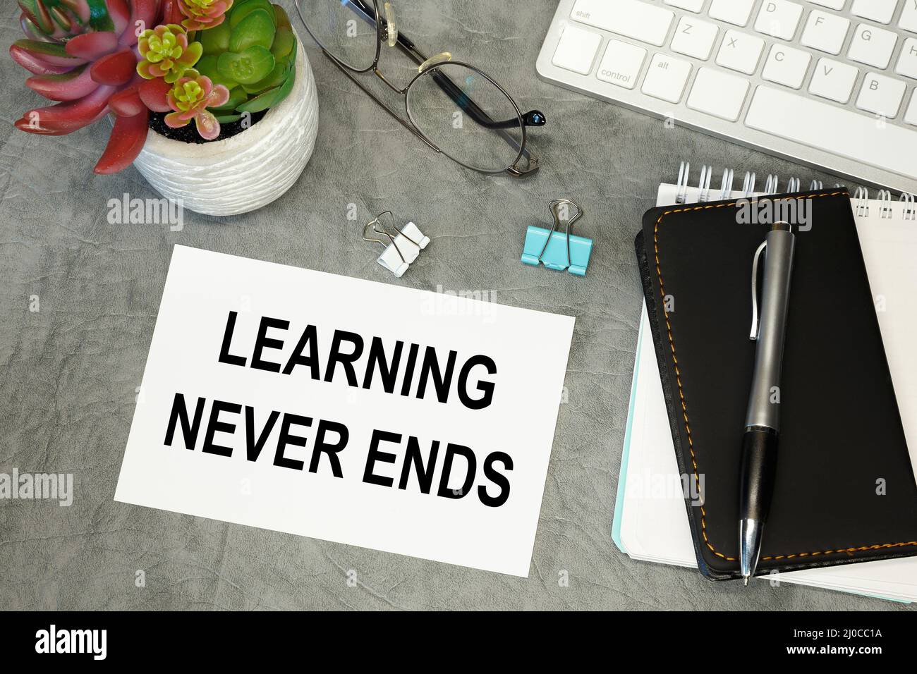 Learning Never Ends - lettering on paper on the desktop, notepad, pen ...