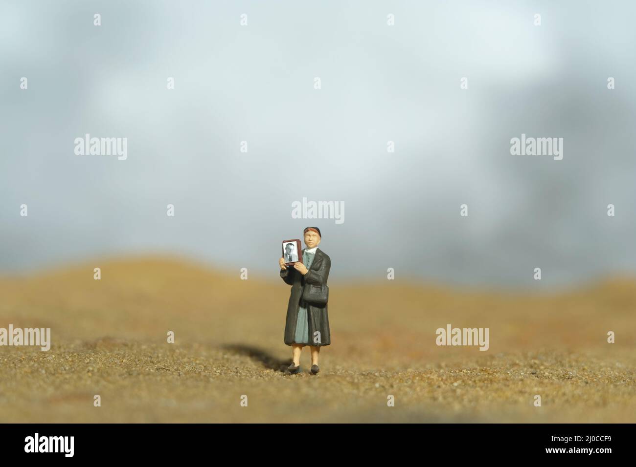 Miniature people toy figure photography. A woman holding photo frame ...