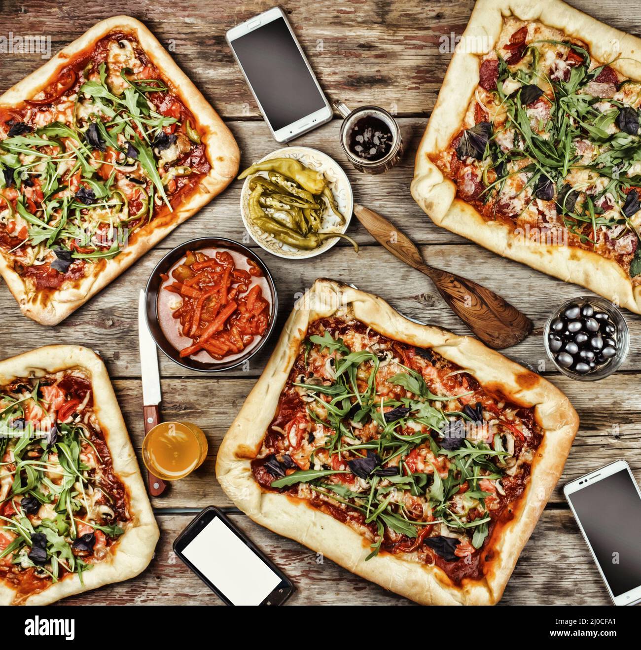 Friendly feast at home. Appetizing homemade pizza on a wooden table ...