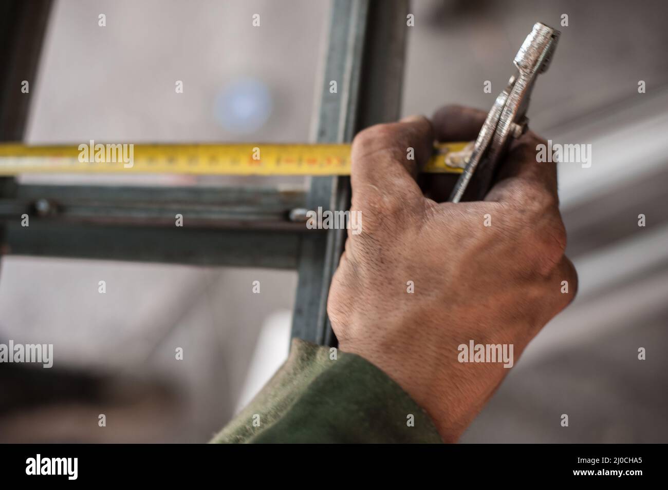 Worker measuring steel with measuring tape. Close up Stock Photo - Alamy