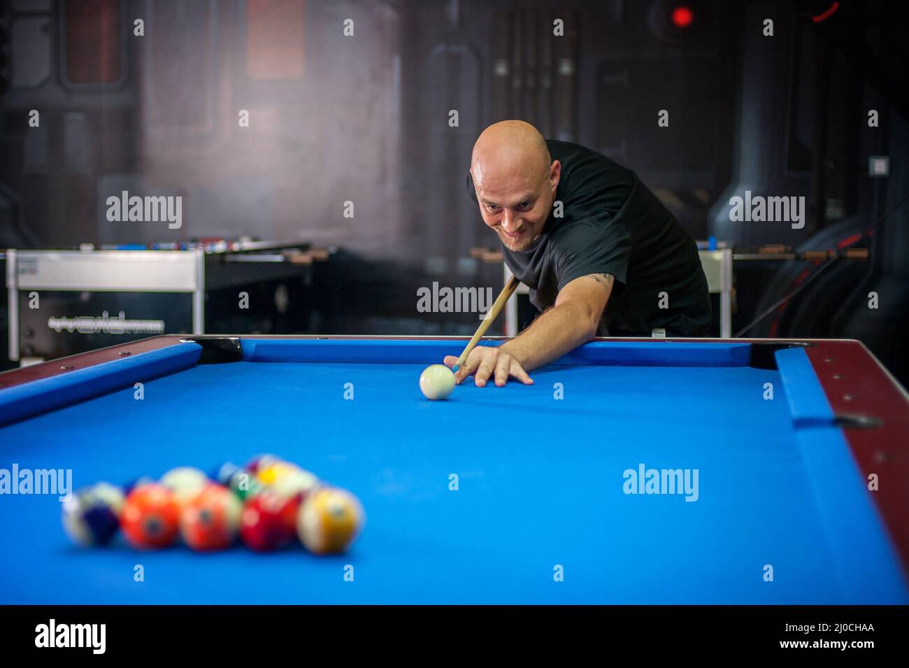 Young man playing billiard in a pool hall Stock Photo - Alamy