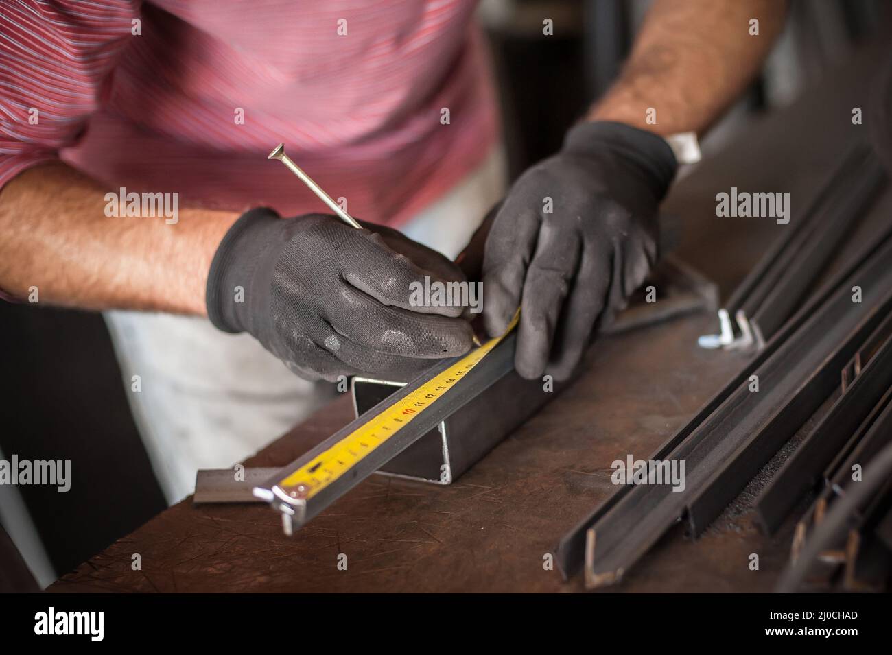 Worker measuring steel with measuring tape. Close up Stock Photo - Alamy
