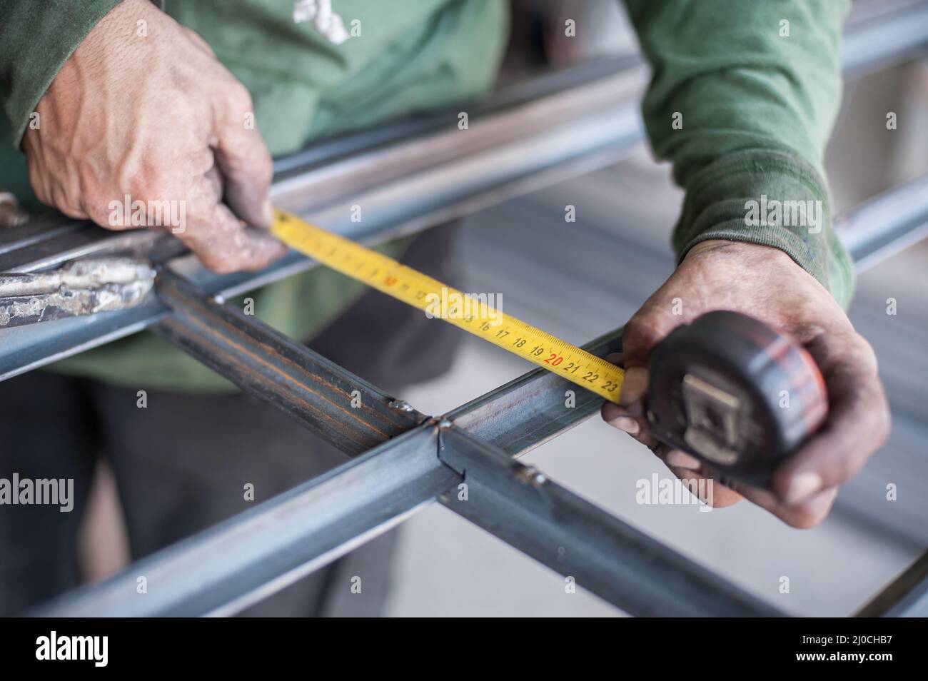 Worker measuring steel with measuring tape. Close up Stock Photo - Alamy