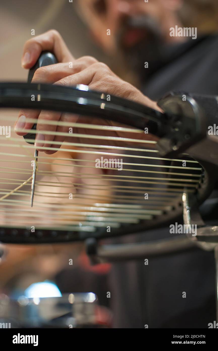 Stringing Machine. Detail of tennis stringer hands while holding awl ...