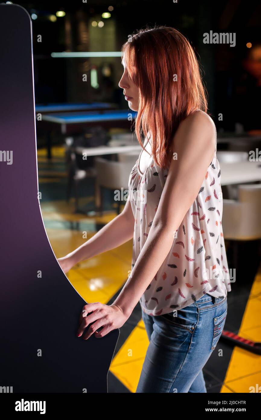 Woman playing on the machines in the amusement arcade Stock Photo - Alamy