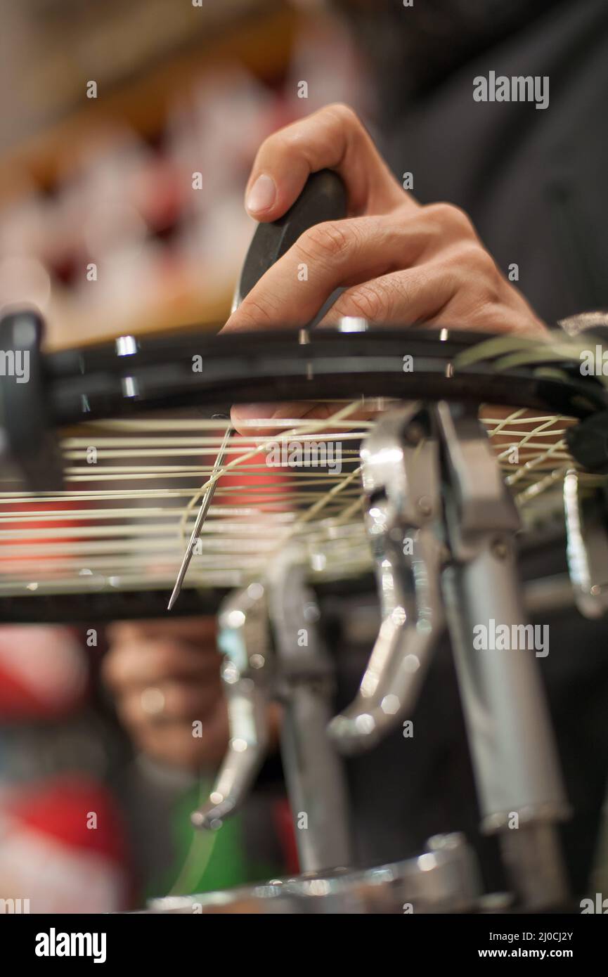 Stringing Machine. Detail of tennis stringer hands while holding awl ...