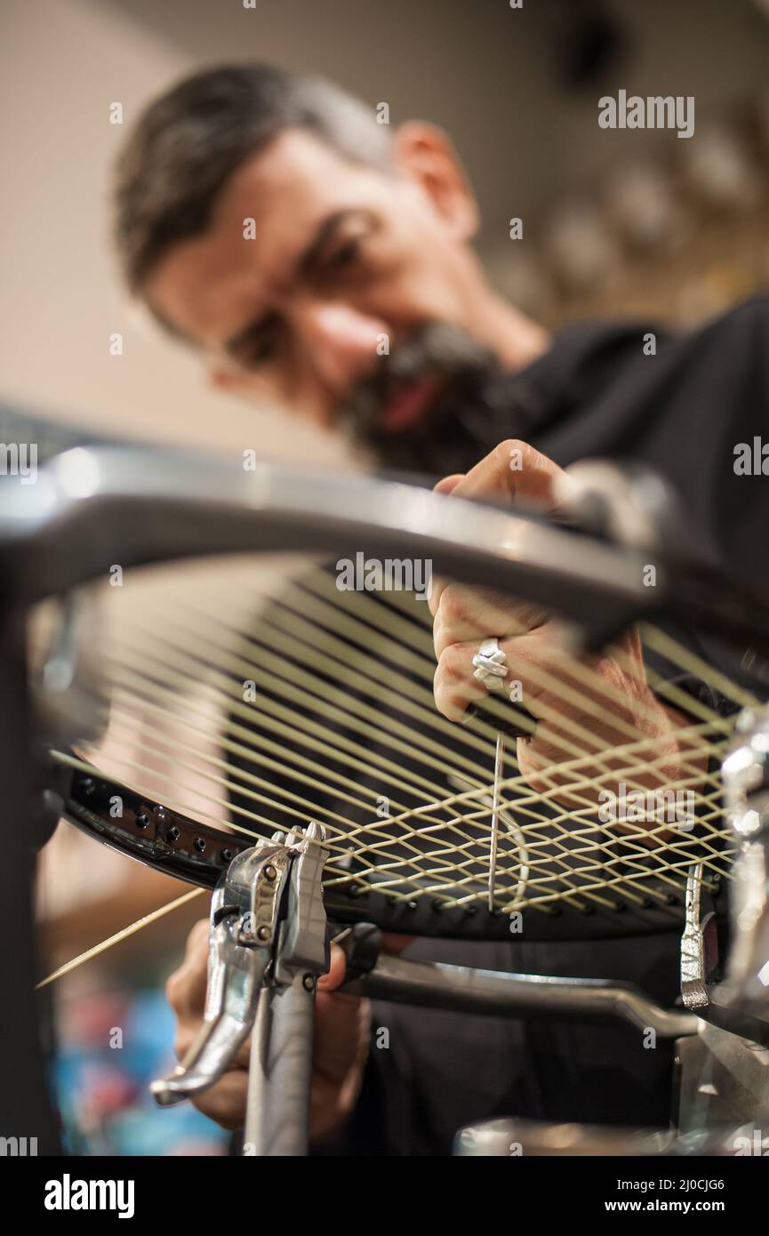 Stringing Machine. Detail of tennis stringer hands while holding awl ...