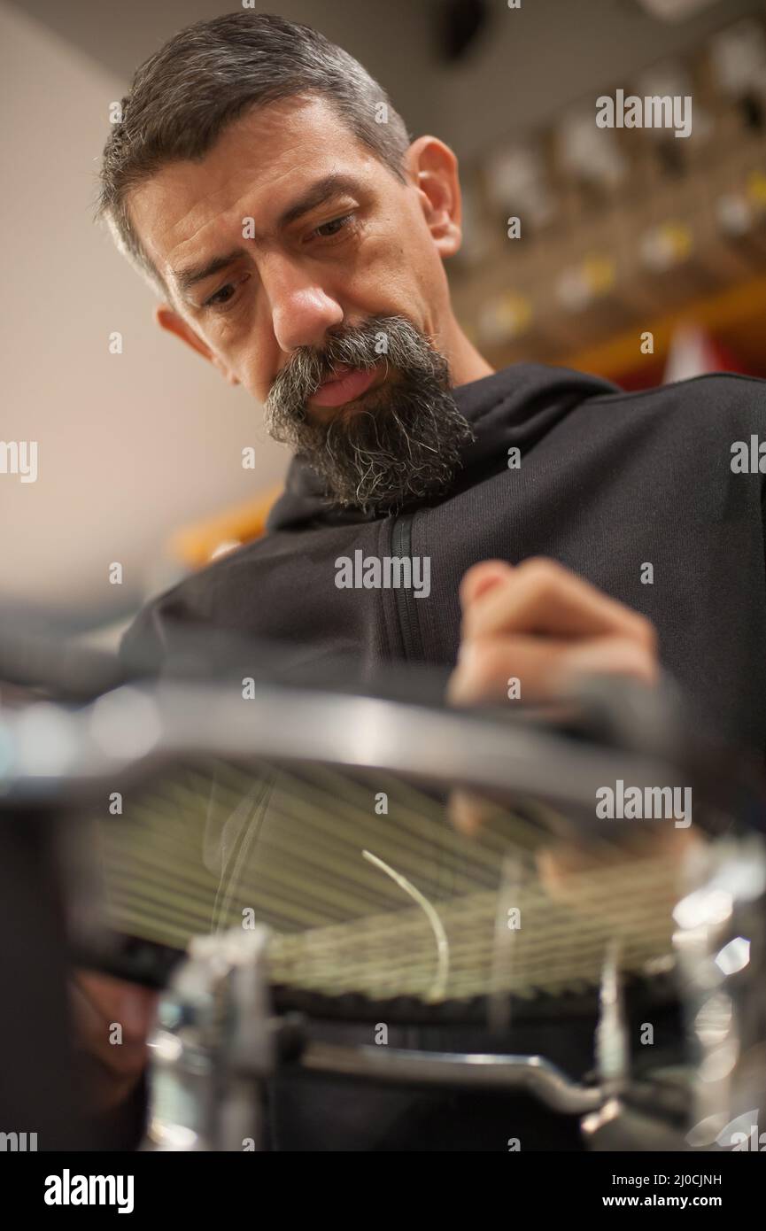 Stringing Machine. Detail of tennis stringer hands while holding awl ...