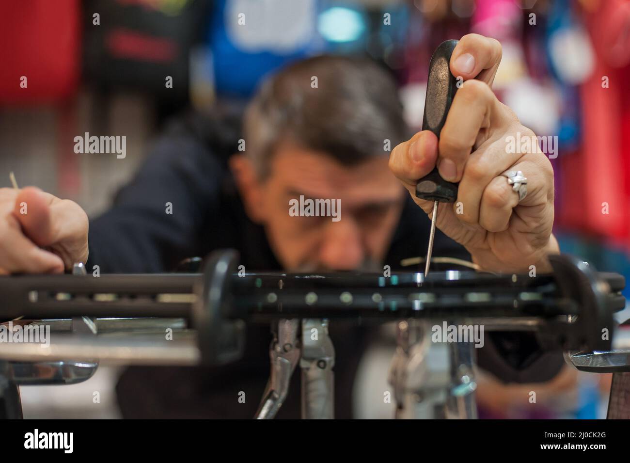 Stringing Machine. Detail of tennis stringer hands while holding awl ...