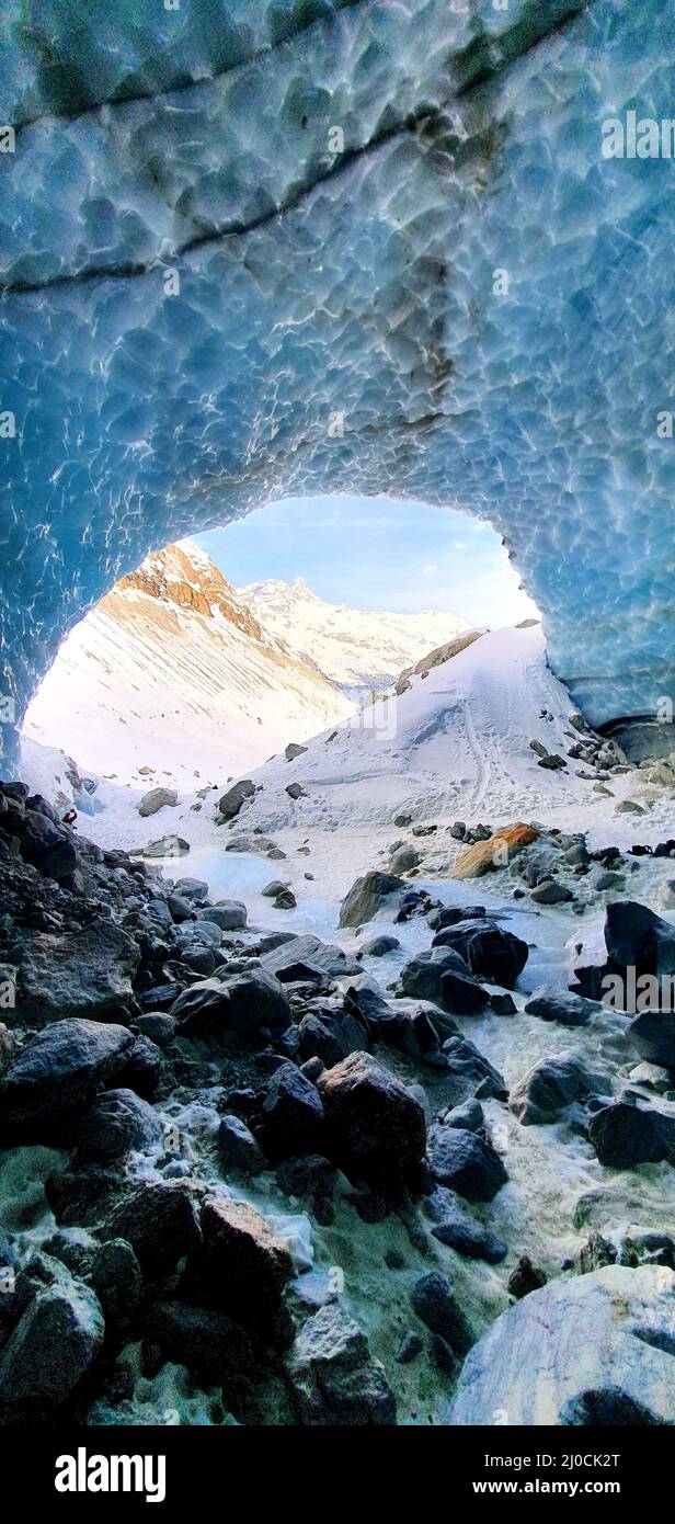 Closeup of a snowy cave with a mountain in the background Stock Photo ...