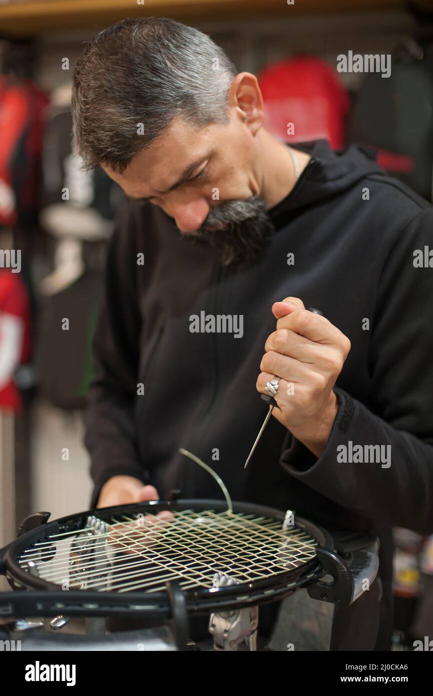 Stringing Machine. Detail of tennis stringer hands while holding awl ...