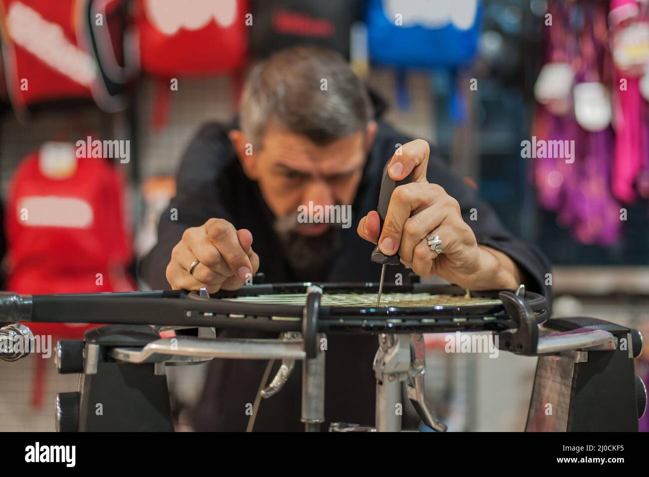 Stringing Machine. Detail of tennis stringer hands while holding awl ...